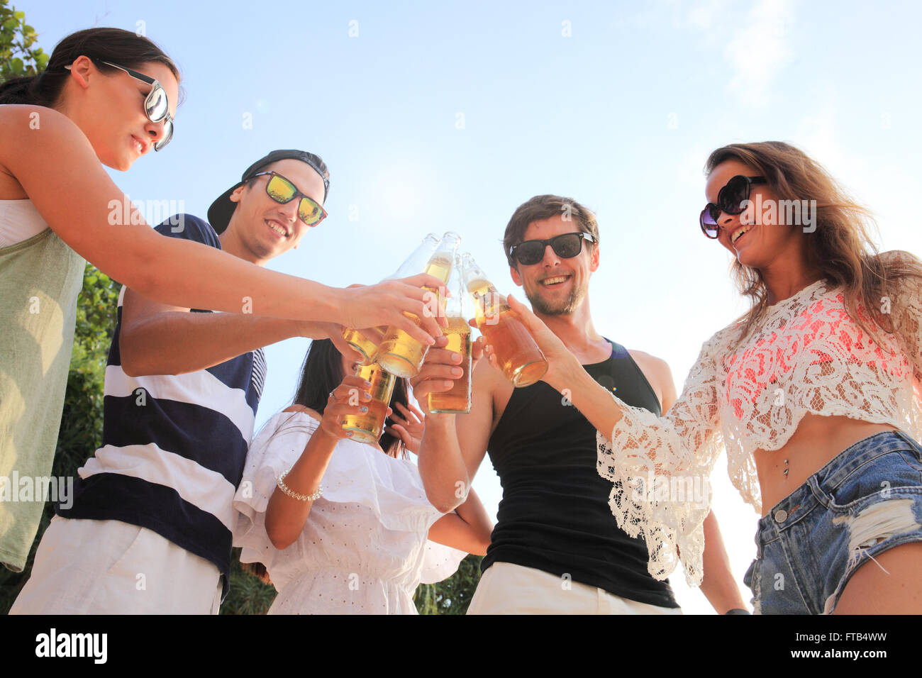 Happy young friends drinking beer outdoors Stock Photo - Alamy