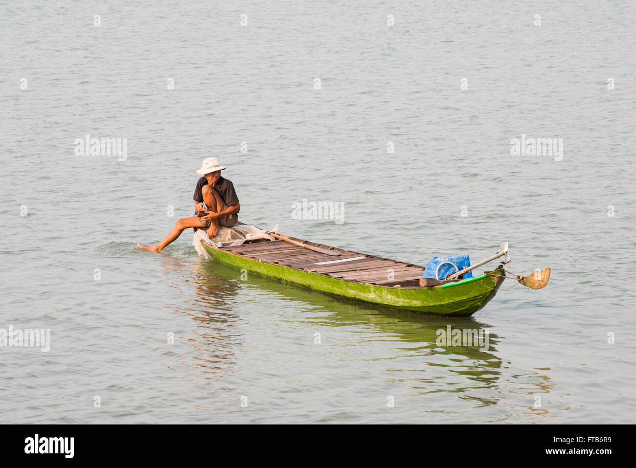 Local fisherman in a traditional, wooden boat looking after his nets on ...