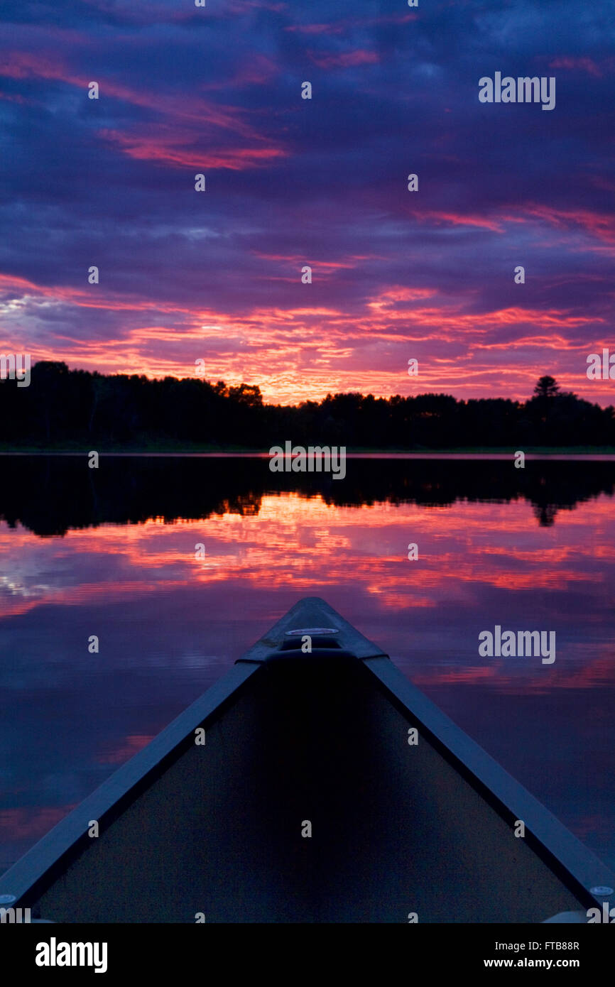 A canoe points to the fading sunset on a calm Minnesota lake Stock ...