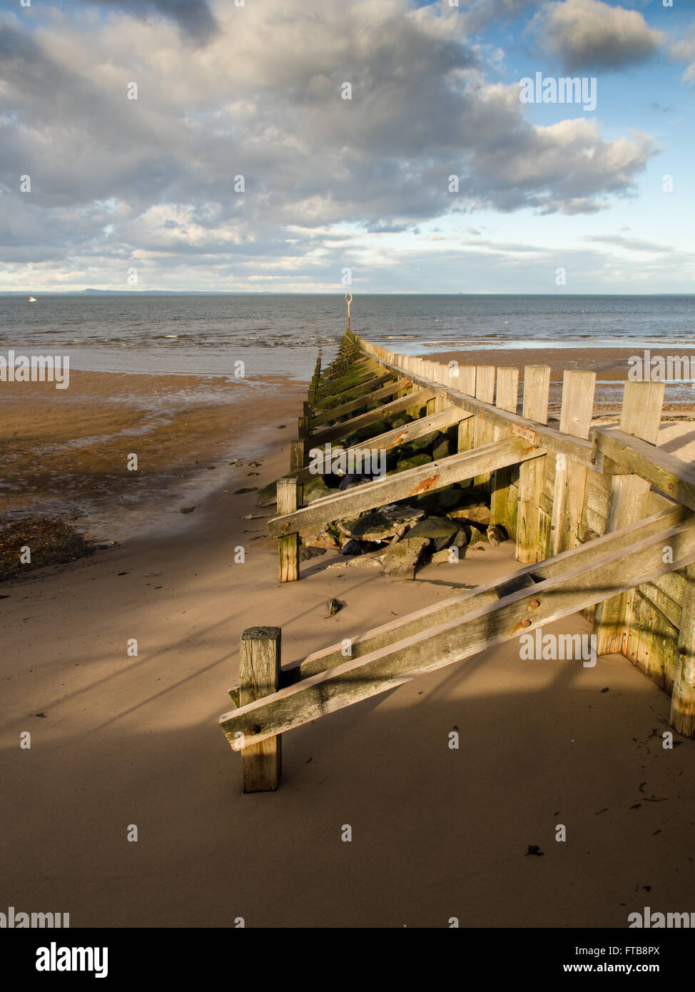 A traditional wooden groyne sea defence on Portobello Beach in Scotland ...