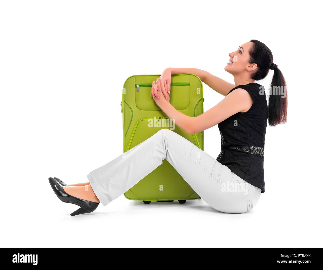 Woman sitting near a suitcase on a white background Stock Photo - Alamy