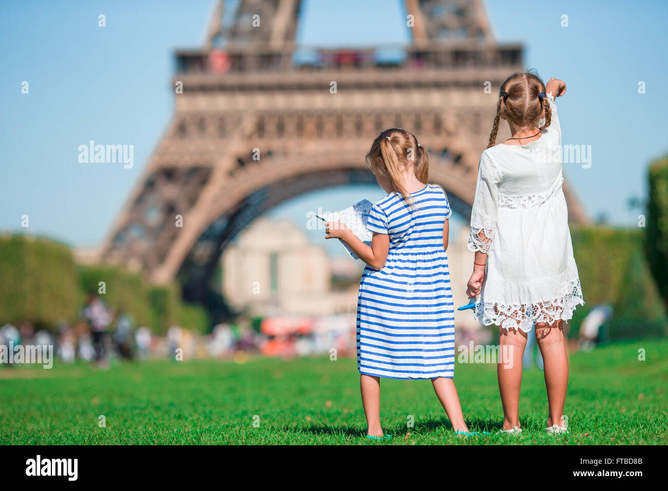 Adorable little girls with map of Paris background the Eiffel tower ...