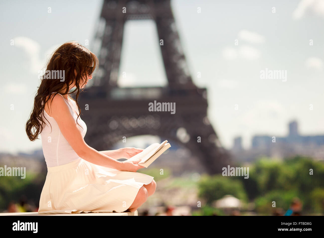 Beautiful woman reading book in Paris background the Eiffel tower Stock ...