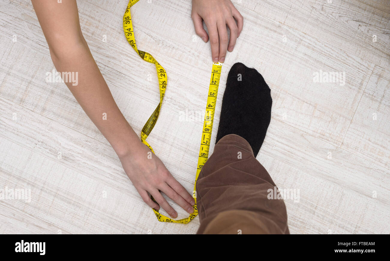 girl measures the size of your male legs Stock Photo - Alamy