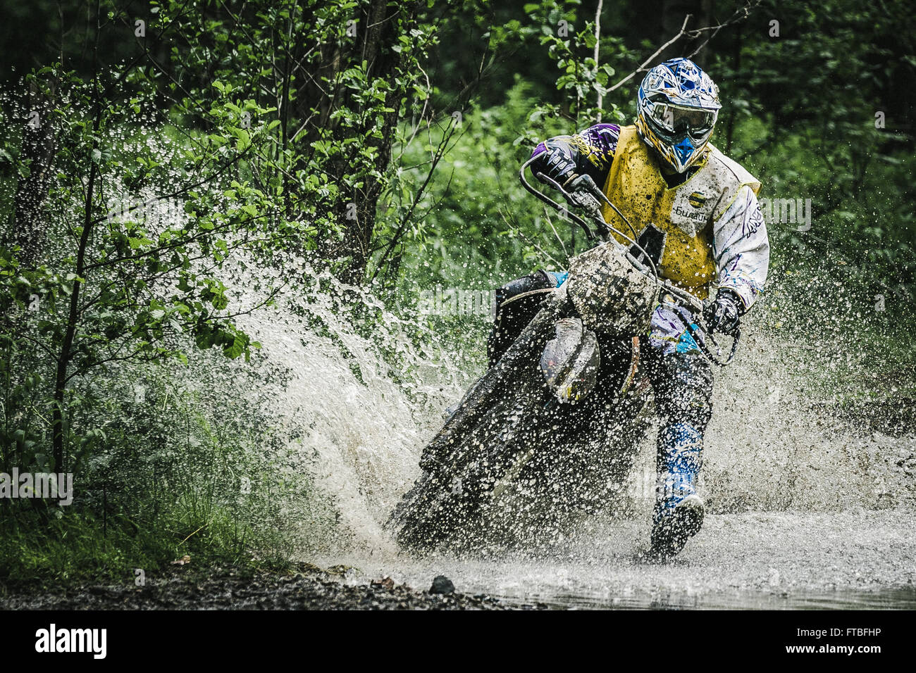 Motocross driver under spray of water competes during race Urals Cup of ...