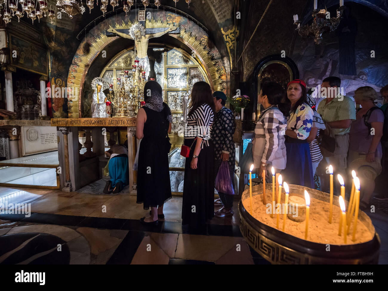 Pilgrims queue to touch the rock of Calvary in Chapel of the ...