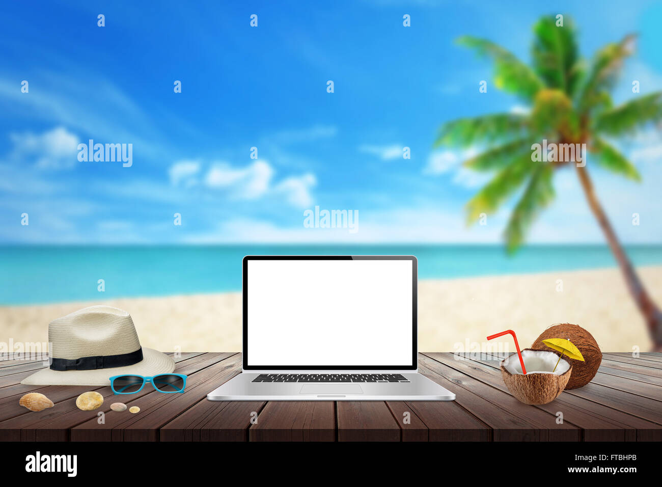 Isolated display of laptop on wooden table for mockup. Coconut, hat ...