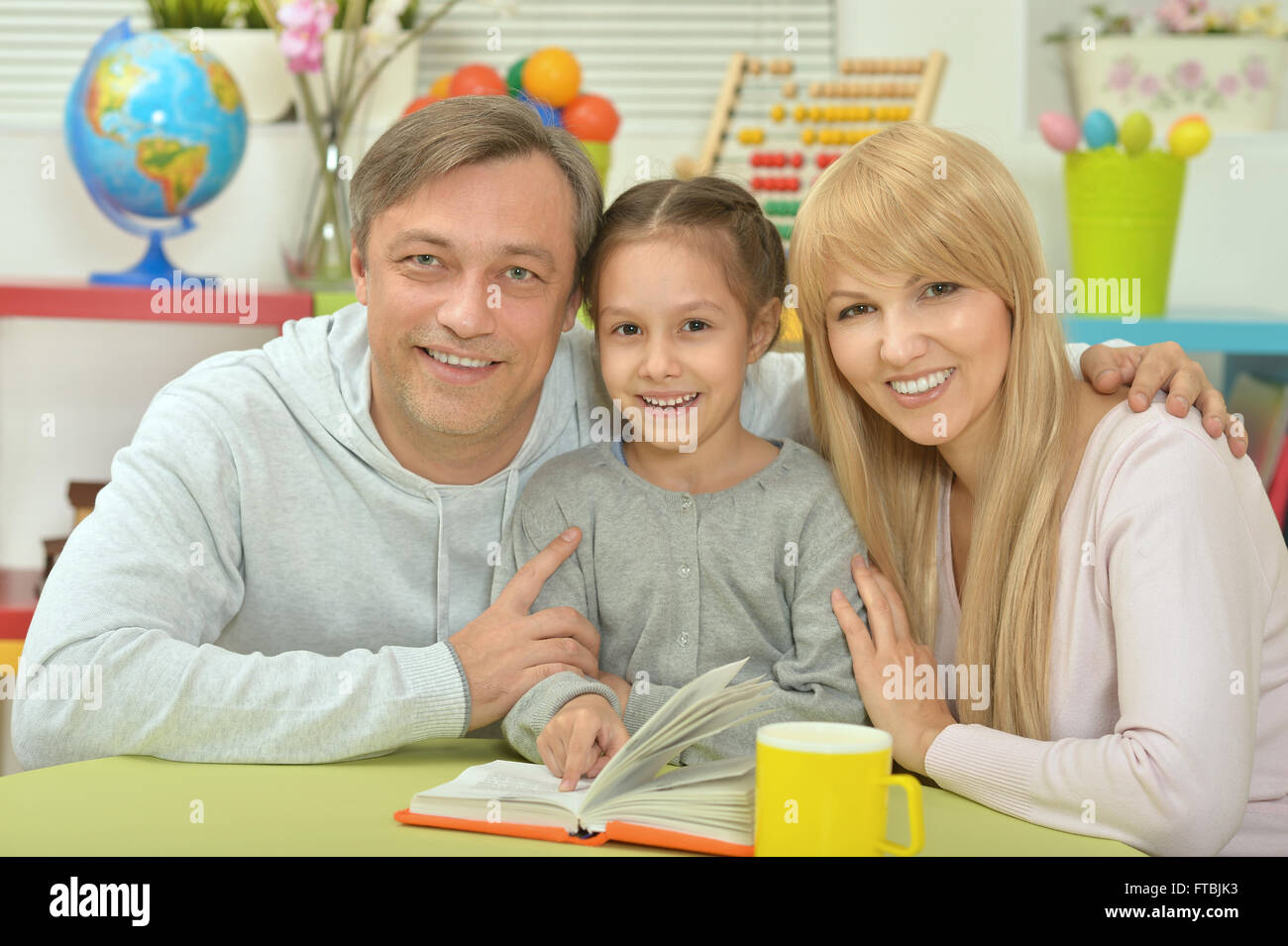 happy family reading the book Stock Photo - Alamy