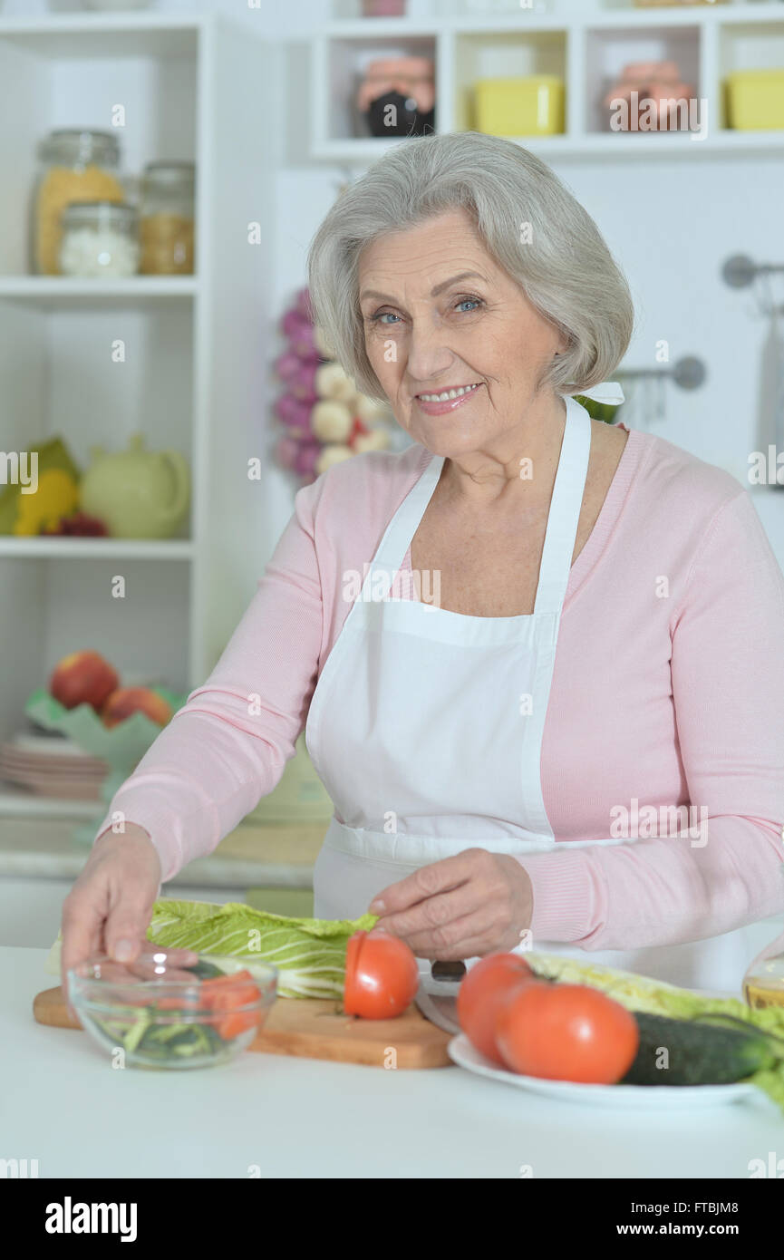 Senior woman cooking in kitchen Stock Photo - Alamy