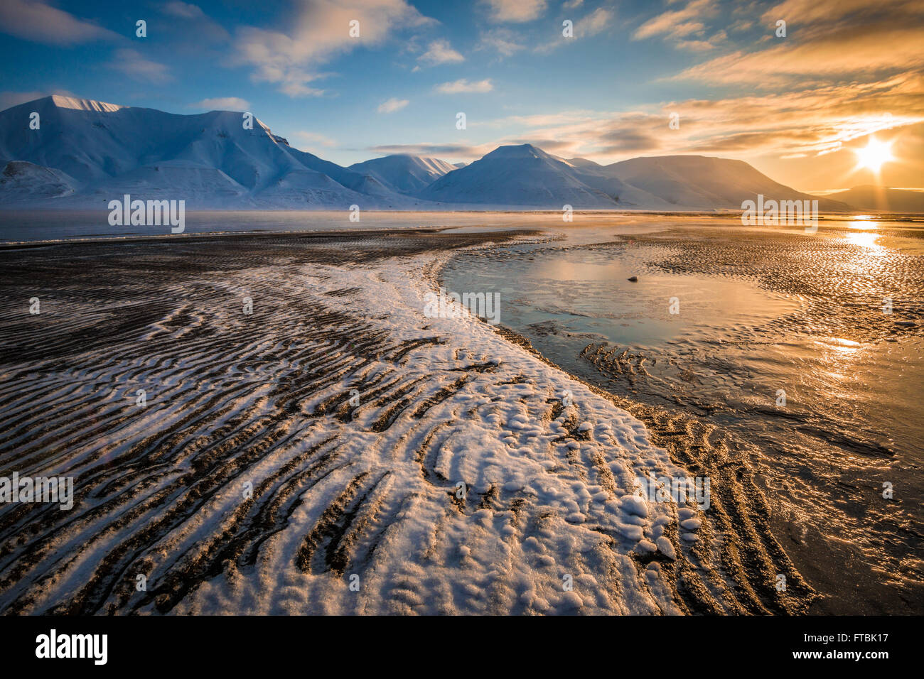 Sunrise ice formations on Sjøskrenten beach with views to Hiorthfjellet ...