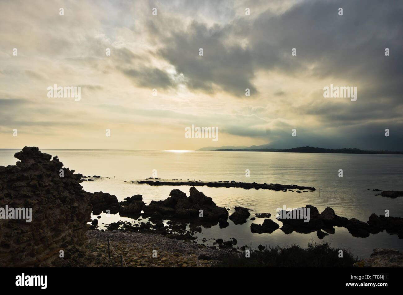 Sunset on a beach at Nora archeological site, near city of Pula, island ...