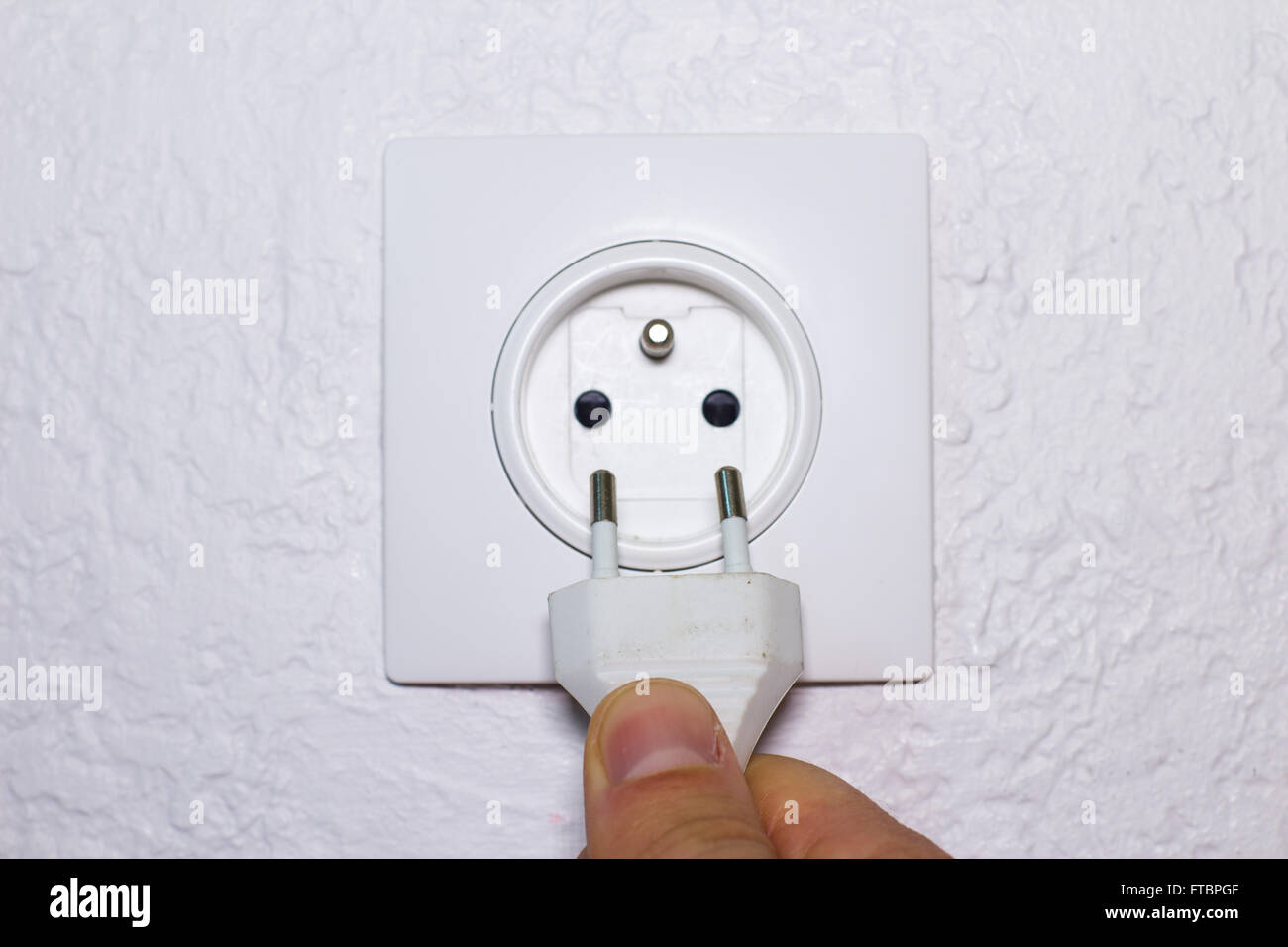 Hand plugs power cord wall hi-res stock photography and images - Alamy