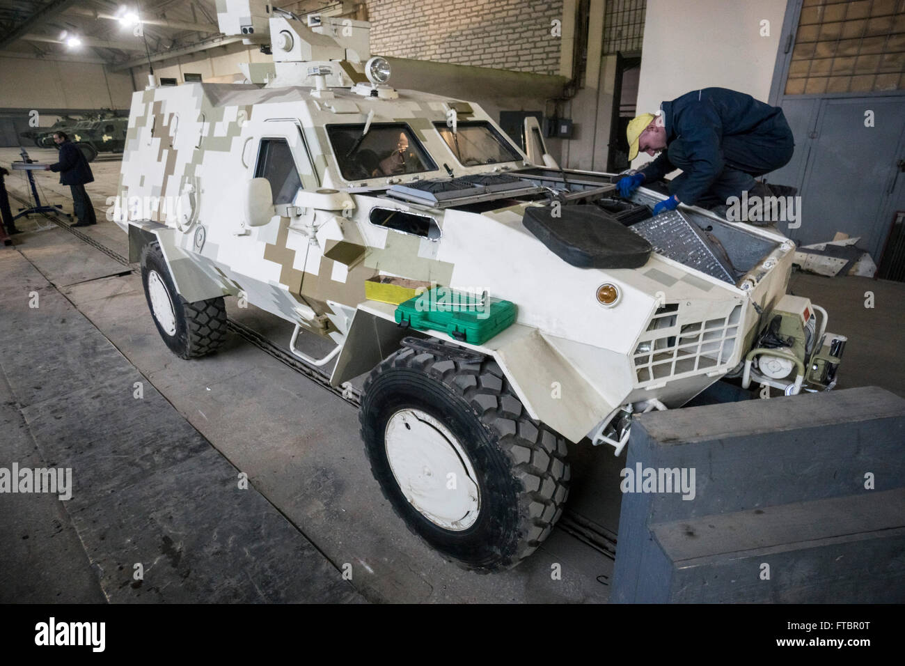 A worker inspects a Dozor-B armoured personnel carrier being ...