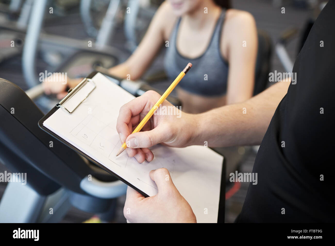 close up of trainer hands with clipboard in gym Stock Photo - Alamy