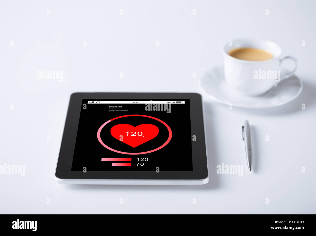 tablet pc with heart rate icon and cup of coffee Stock Photo - Alamy
