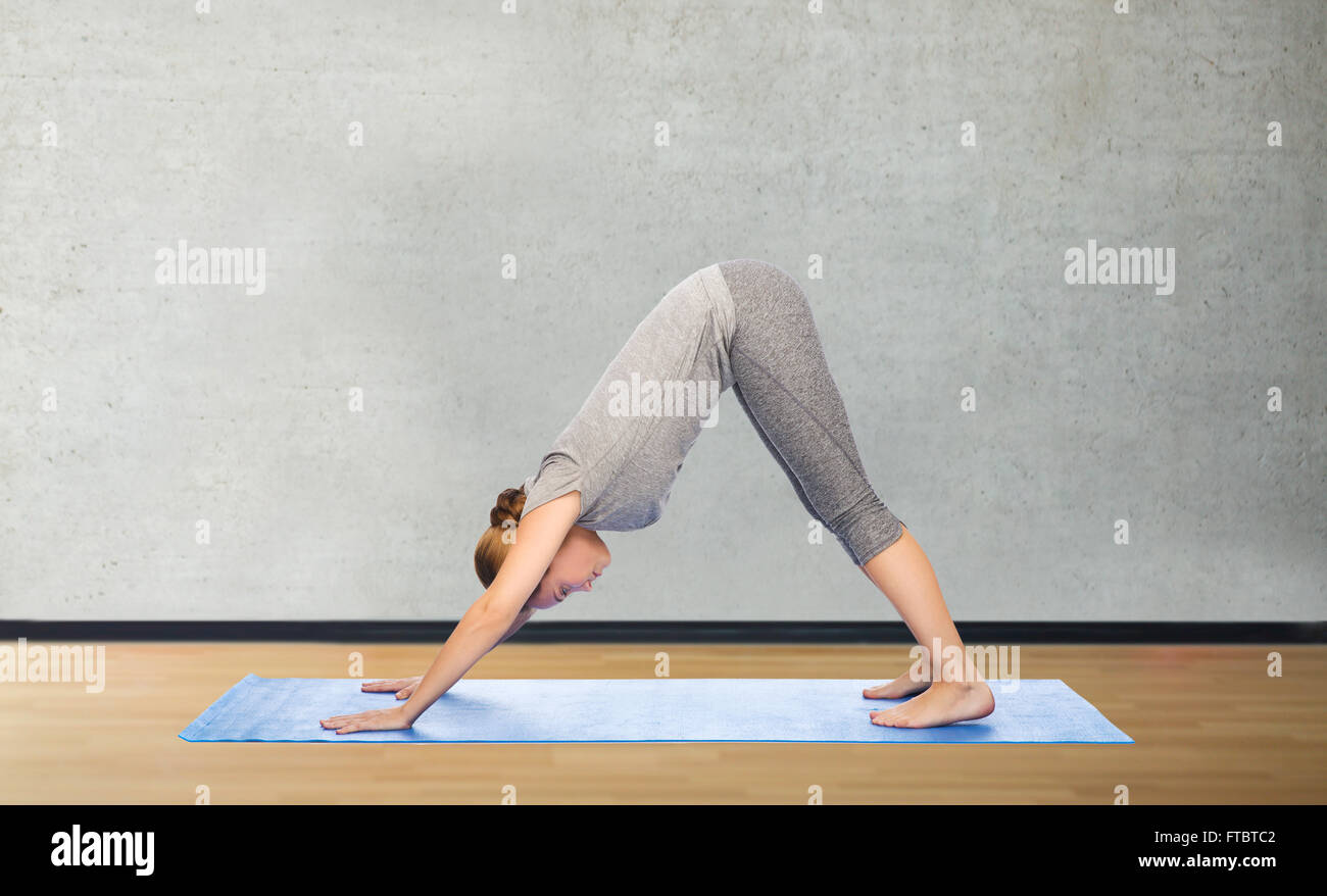 woman making yoga dog pose on mat Stock Photo - Alamy