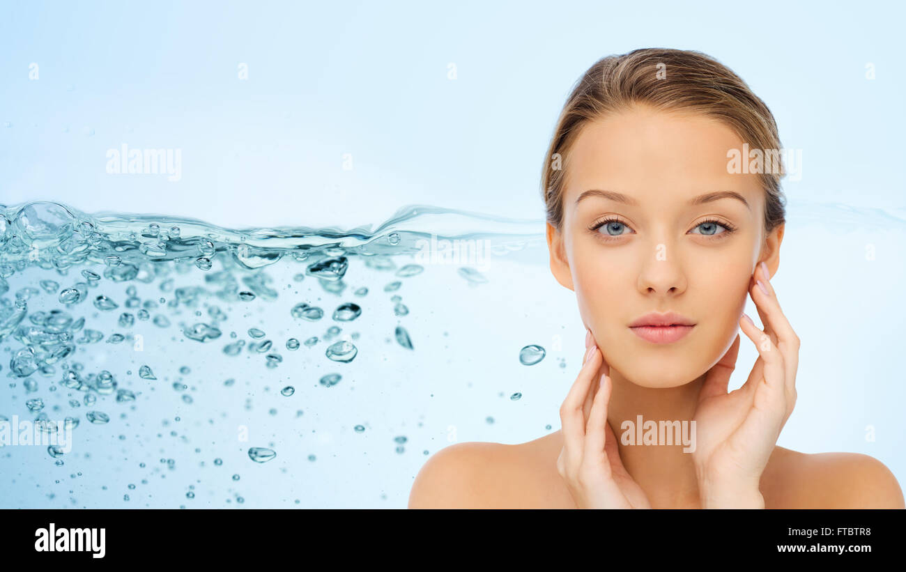 young woman touching her face Stock Photo - Alamy