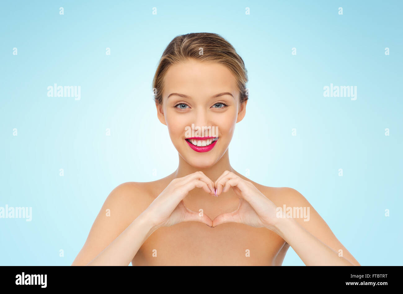 smiling young woman showing heart shape hand sign Stock Photo - Alamy