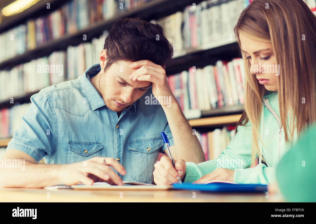 students writing to notebooks in library Stock Photo - Alamy