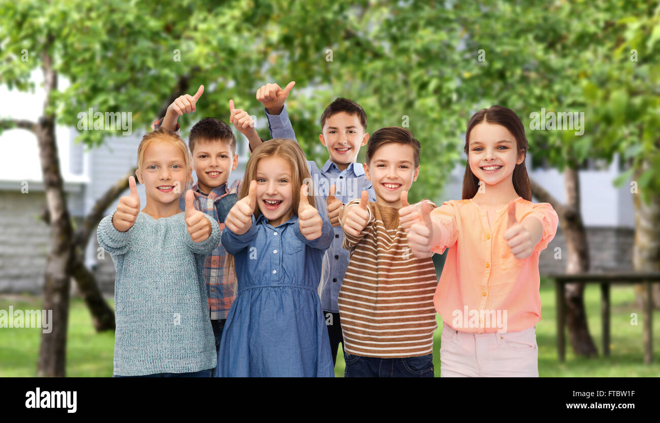 happy children showing thumbs up over backyard Stock Photo - Alamy
