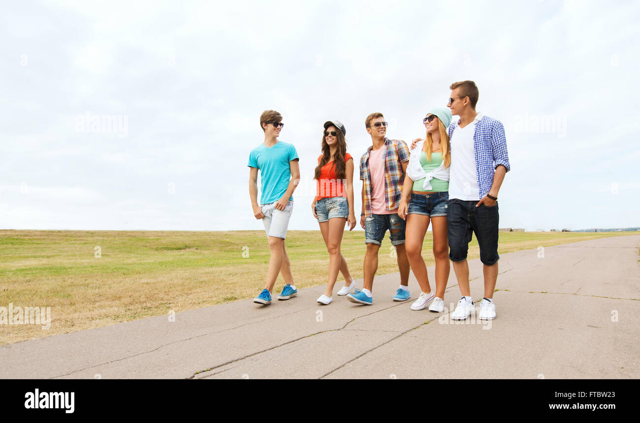 group of smiling friends walking on road Stock Photo - Alamy