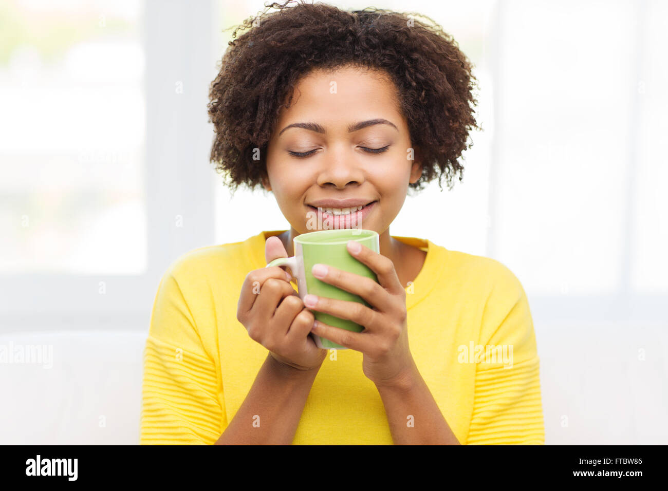 happy african american woman drinking from tea cup Stock Photo - Alamy
