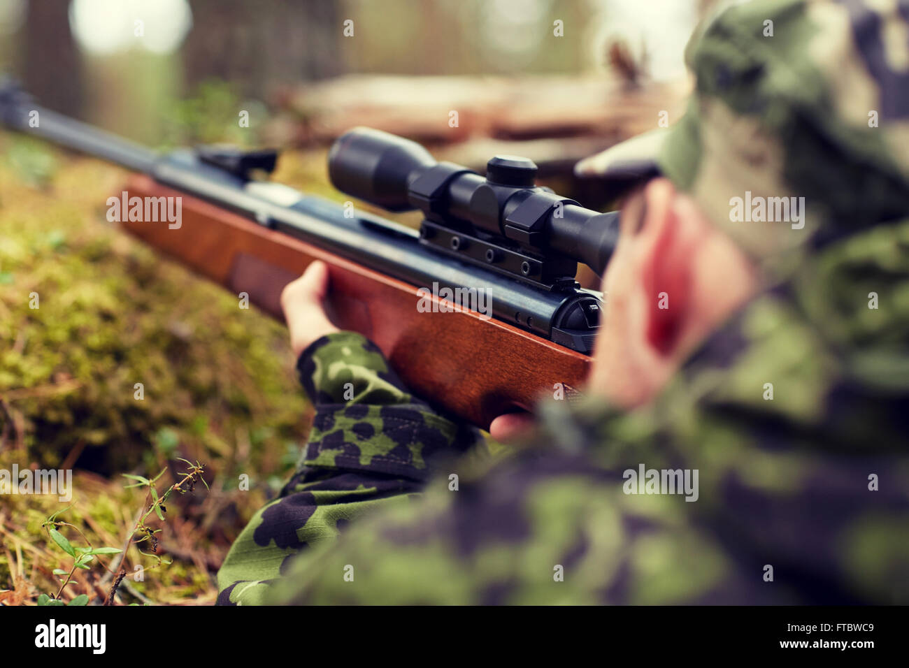 soldier or hunter shooting with gun in forest Stock Photo - Alamy