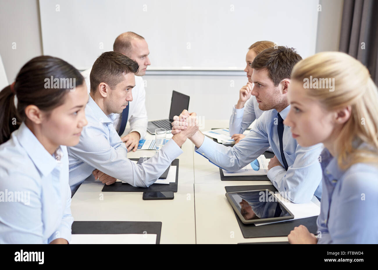 smiling business people having conflict in office Stock Photo - Alamy