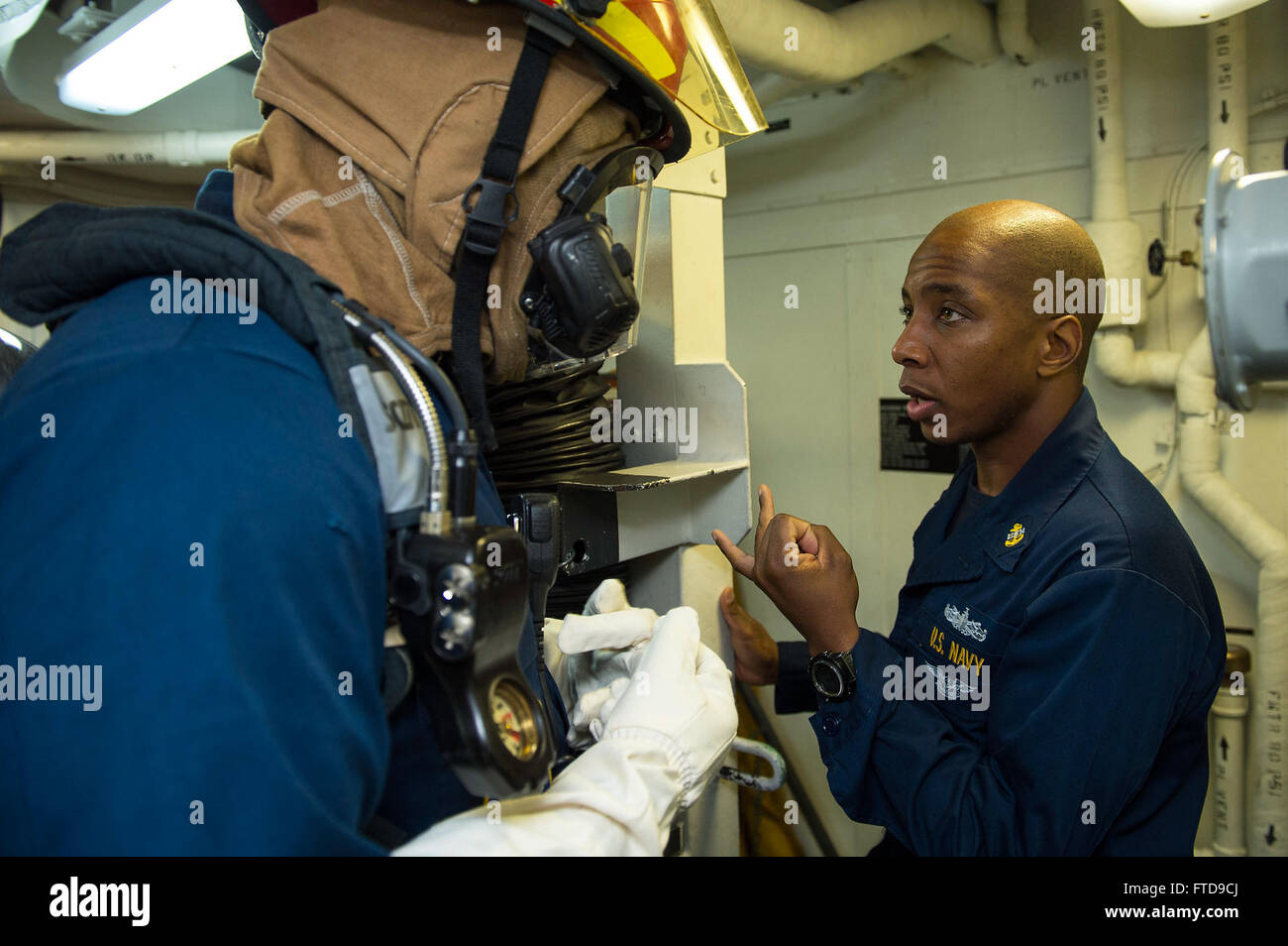 Chief Damage Controlman Reginald Pridgen coordinates a firefighting ...
