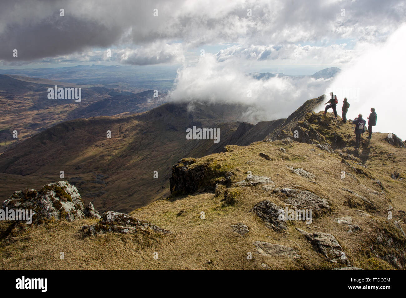 Walkers admire the view as clouds flow over the Crib Goch Ridge ...