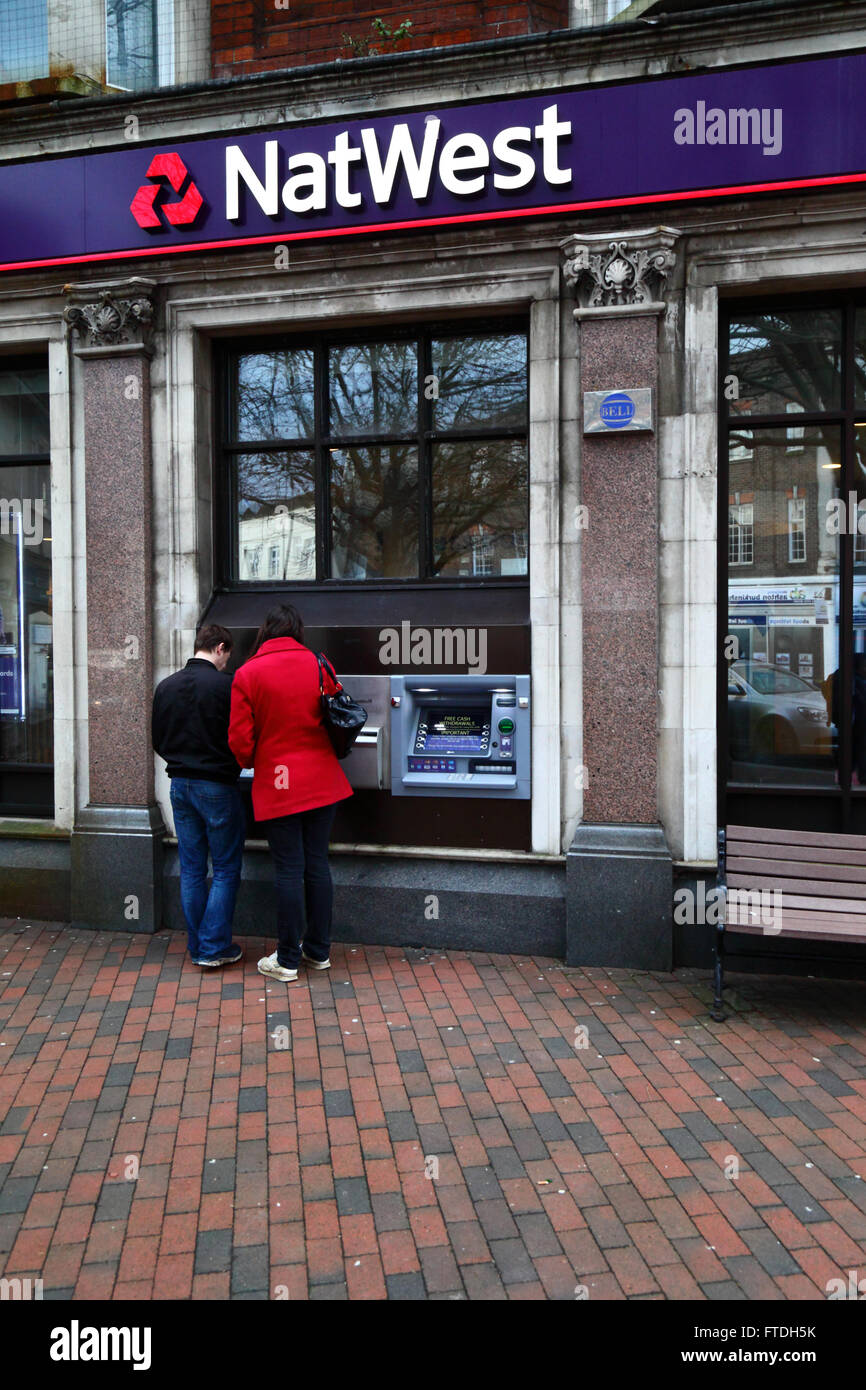 Couple using NatWest bank cash machine / ATM on High Street, Tonbridge ...