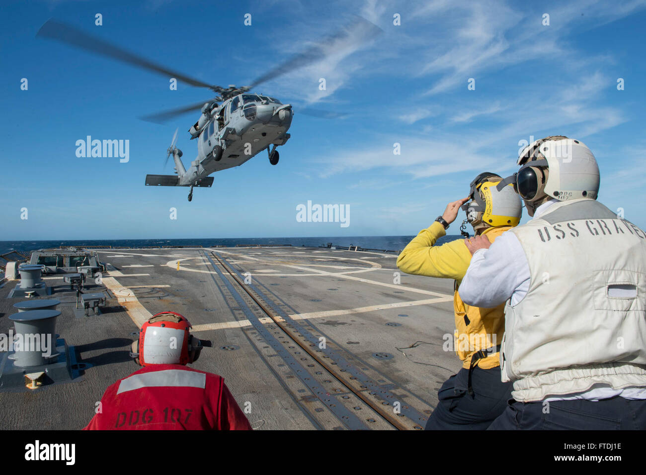 The image captures an MH-60S Sea Hawk helicopter landing aboard the USS ...