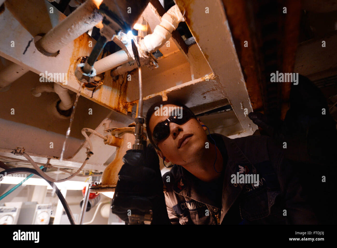 Hull Technician 2nd Class Devon Cummings performs maintenance on a fire ...