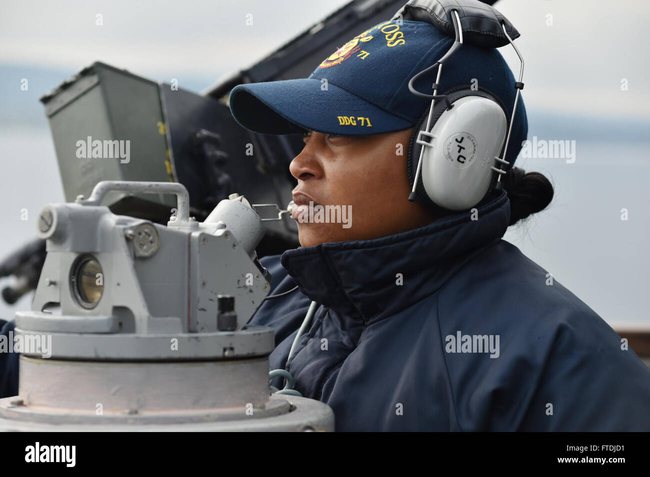 This photo captures a U.S. Navy sailor standing watch aboard the USS ...