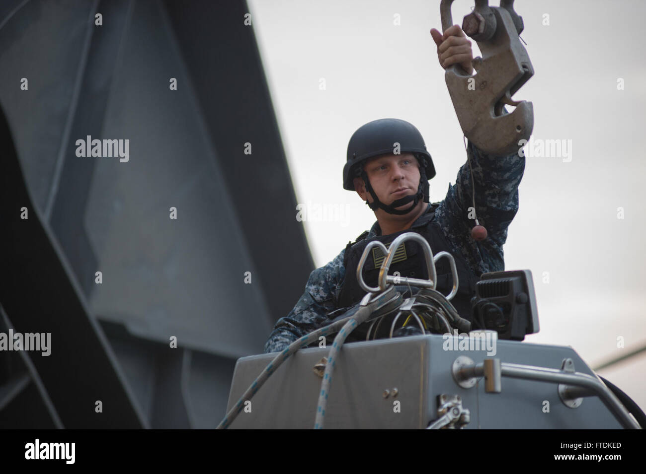 Engineman 2nd Class Rory Parker attaches a rigid hull inflatable boat ...