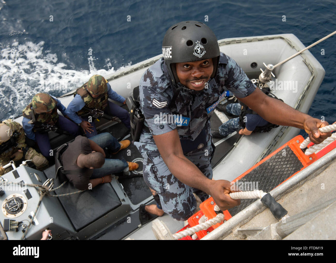 This photograph shows a Ghanaian boarding team member descending a ...