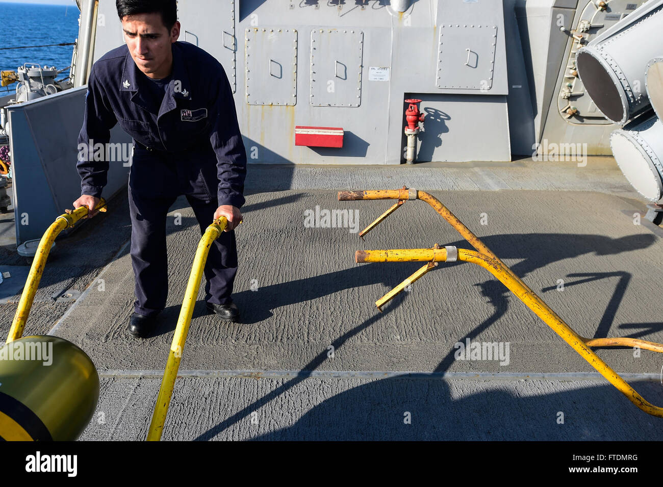 Fire Controlman 2nd Class Azareel Castro moves a Mark 46 torpedo aboard ...