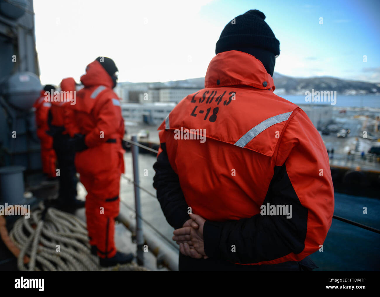 Sailors aboard the USS Fort McHenry (LSD 43) man the rails as the ship ...