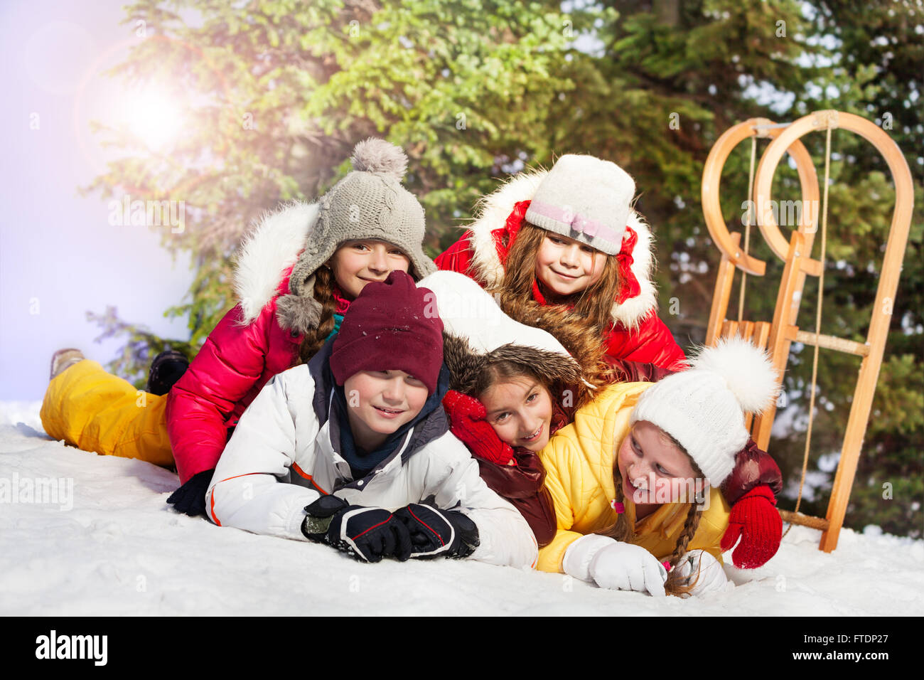 Happy friends laying at the snow in winter forest Stock Photo - Alamy