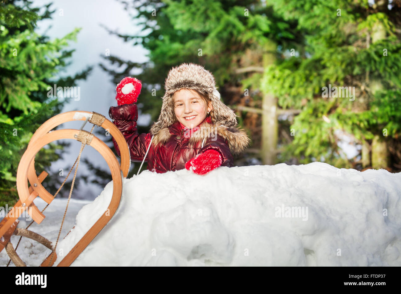 Smiling girl throwing snowball from the snow tower Stock Photo - Alamy