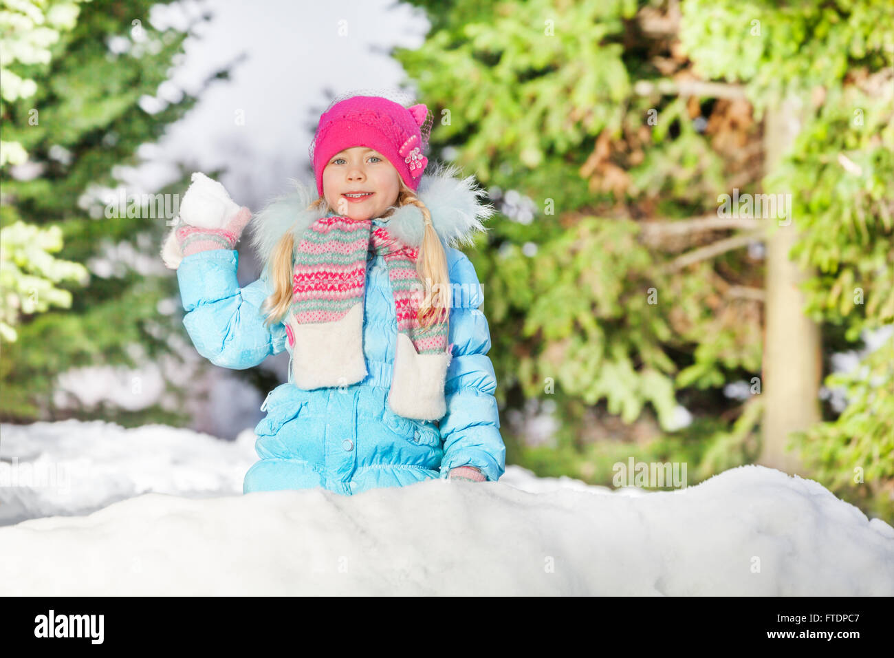 Little girl throw snowball hiding behind snow wall Stock Photo - Alamy