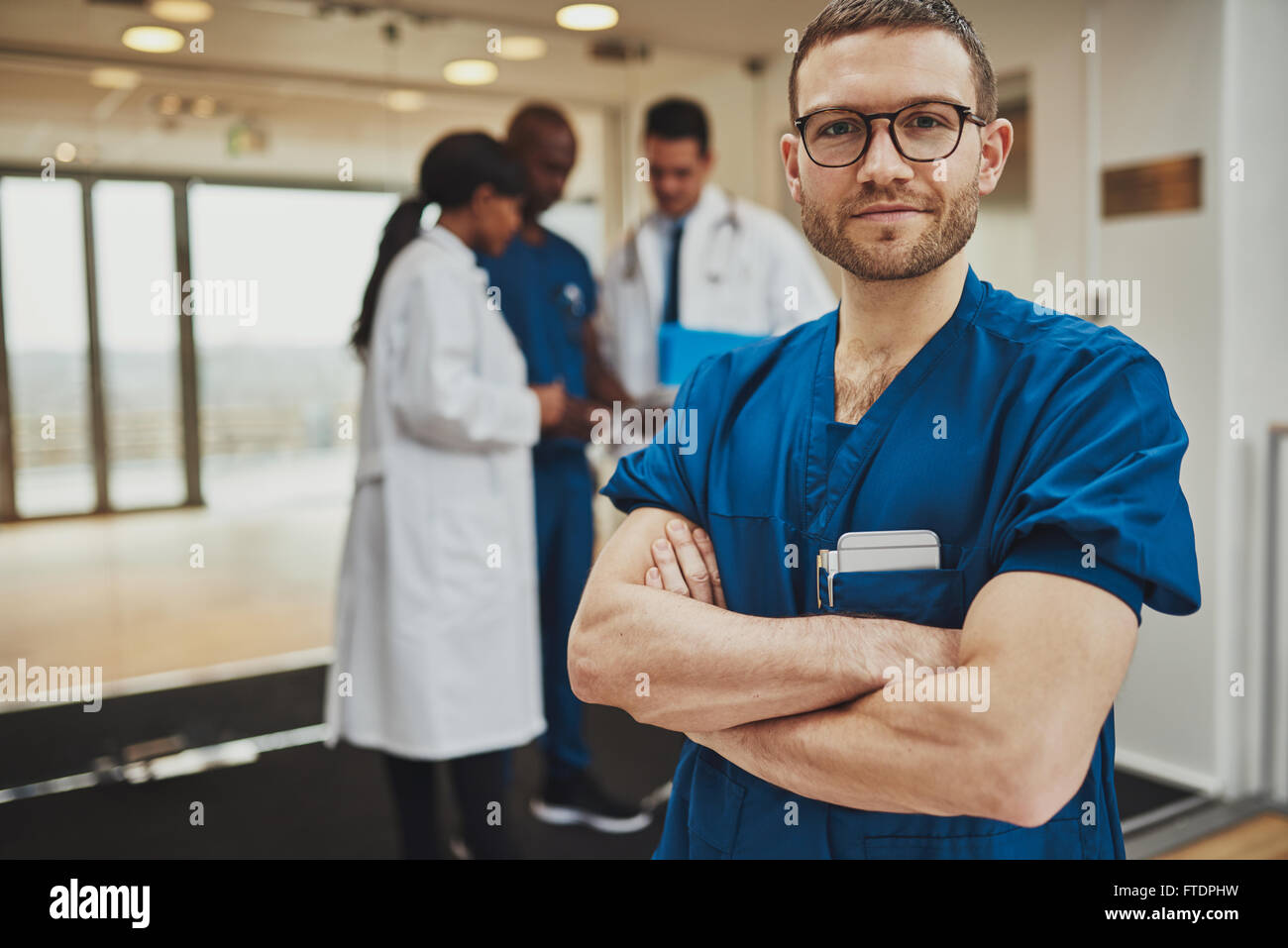 Confident relaxed surgeon doctor at hospital with team of doctors in ...