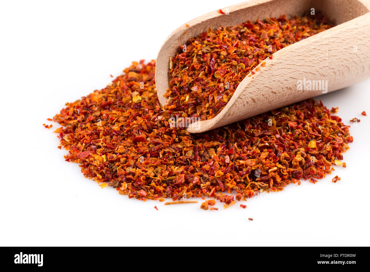 Crushed red chili pepper in spoon on white background Stock Photo - Alamy