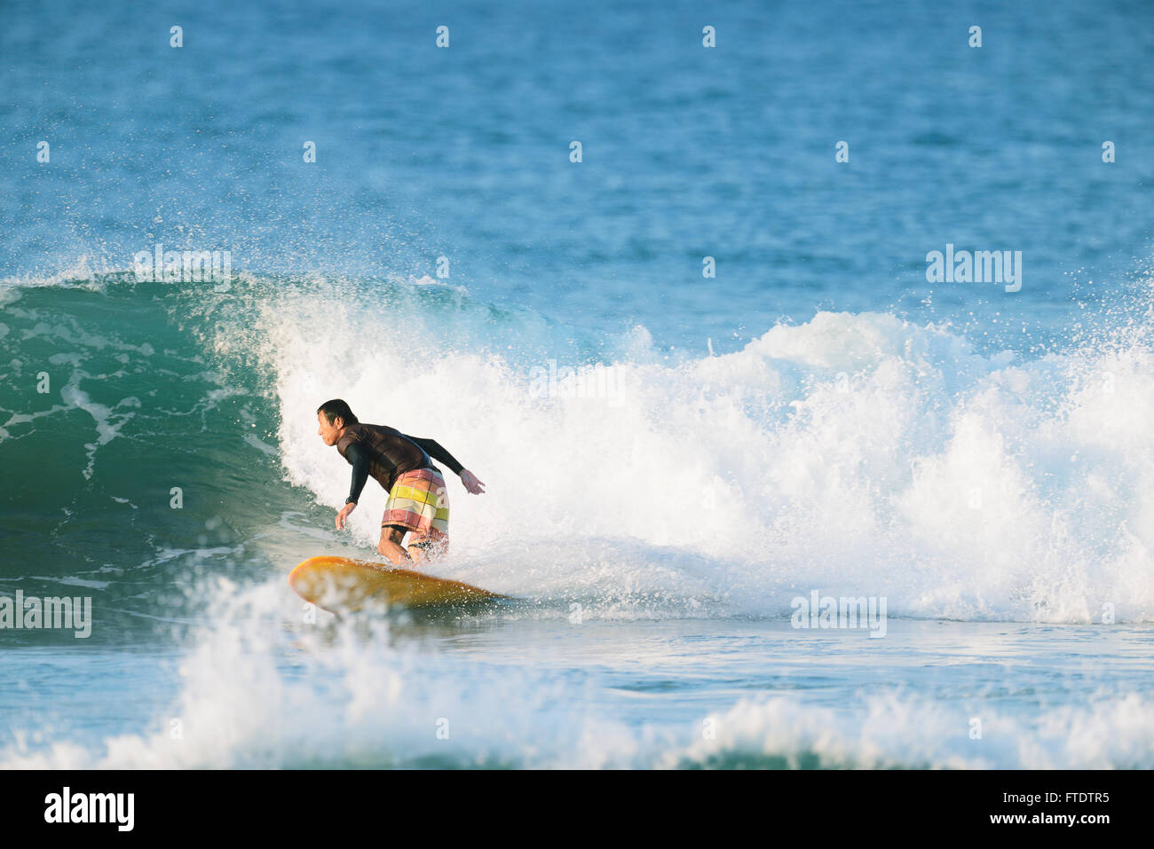 Japanese surfer riding wave Stock Photo - Alamy