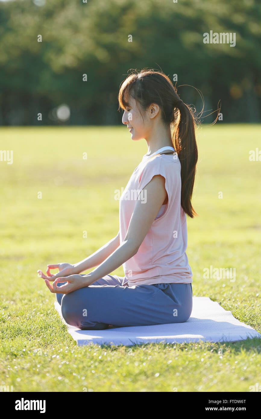 Young Japanese woman practicing yoga in a city park Stock Photo - Alamy