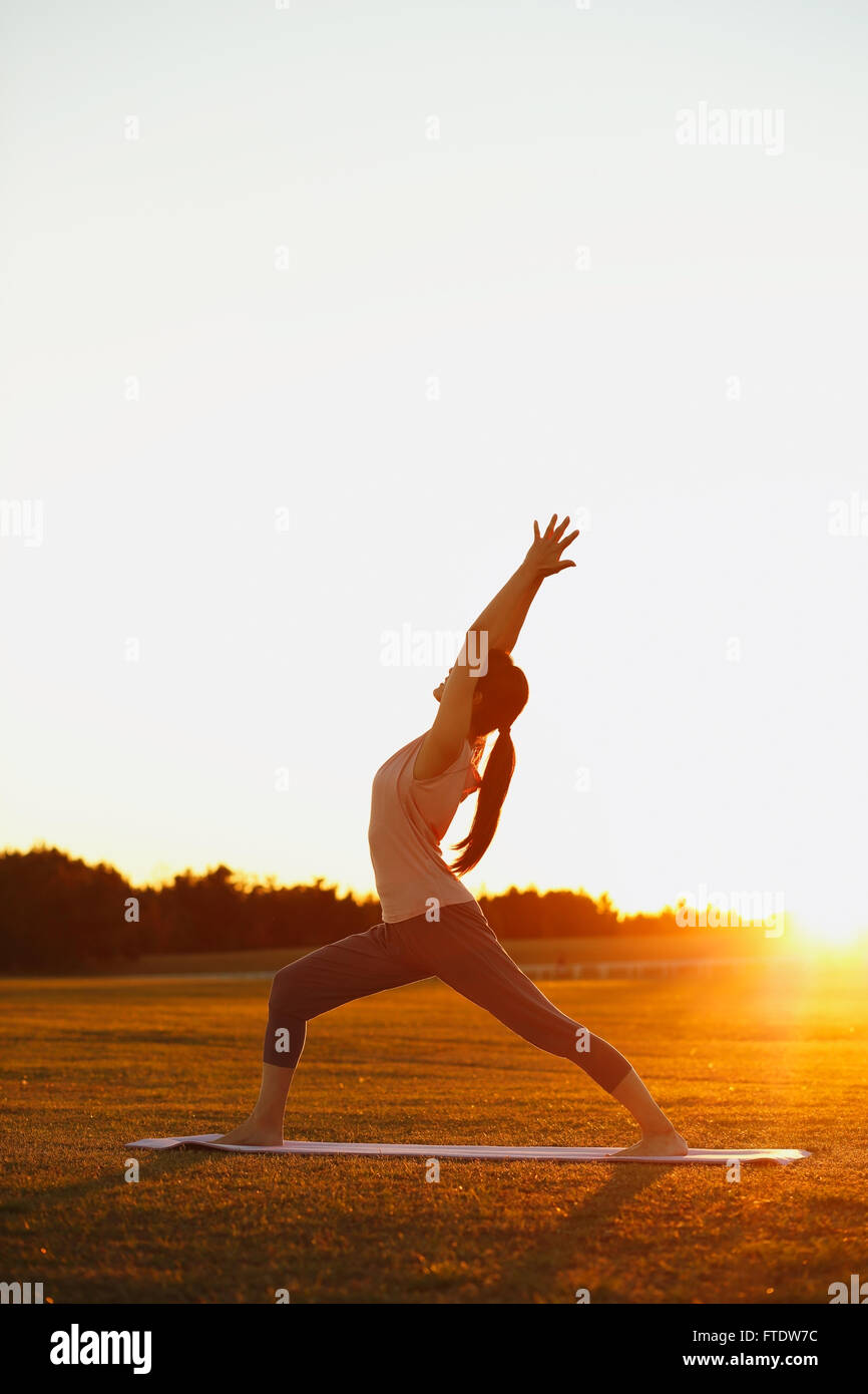 Young Japanese woman practicing yoga in a city park Stock Photo - Alamy