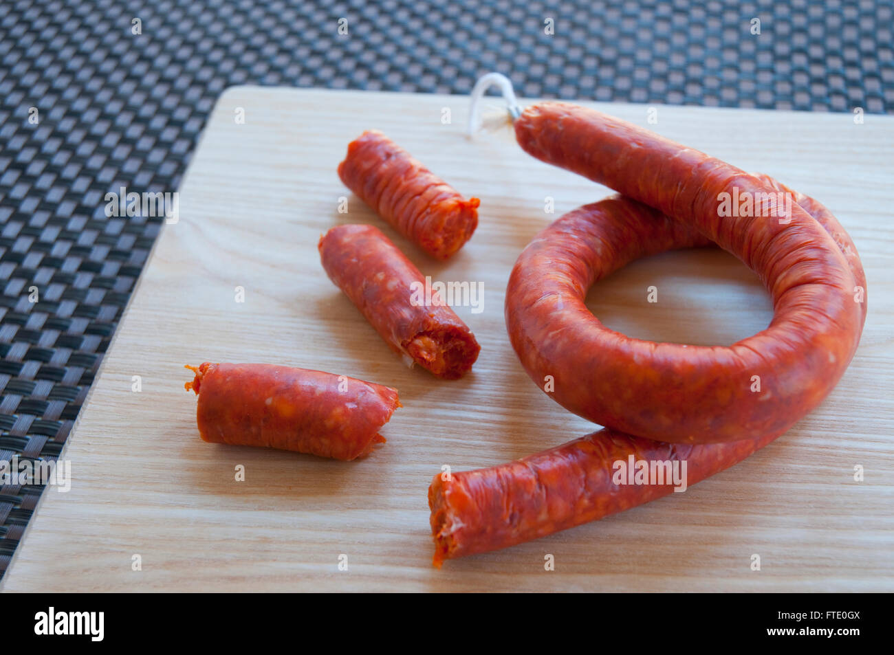 Chistorra on wooden chopping board. Spain Stock Photo - Alamy