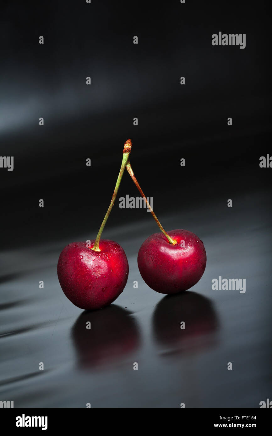 Cherry on black reflective background Stock Photo - Alamy