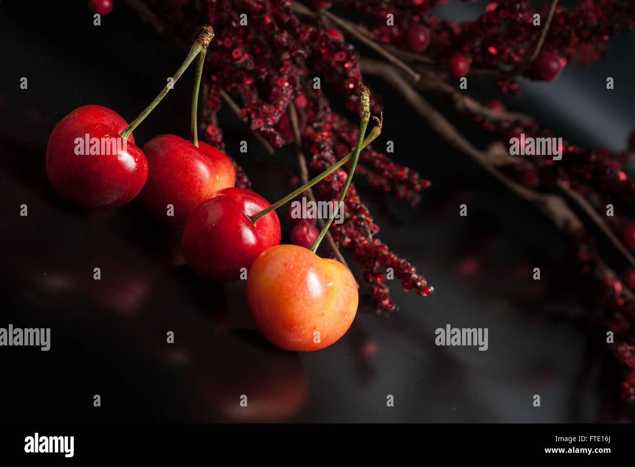 Yellow cherry on black reflective background Stock Photo - Alamy