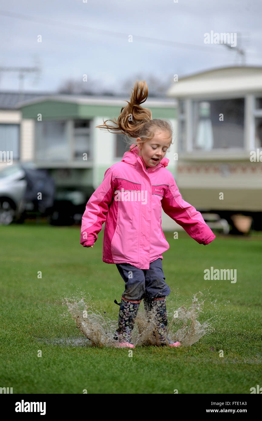 A little girl enjoys jumping in a puddle left by Storm Katie at a ...